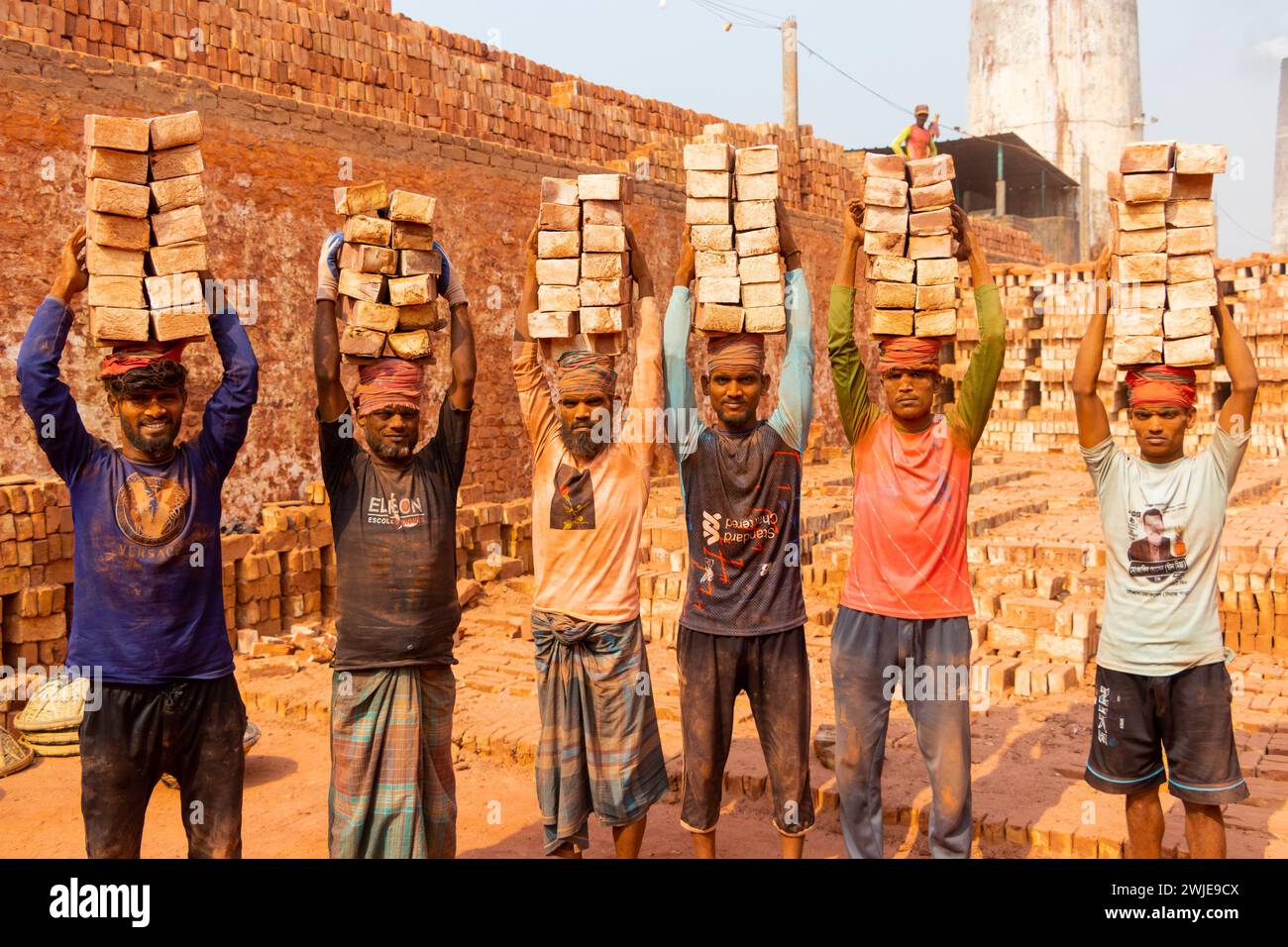 Dhaka, Dhaka, Bangladesh. 15th Feb, 2024. Workers carry piles of bricks ...