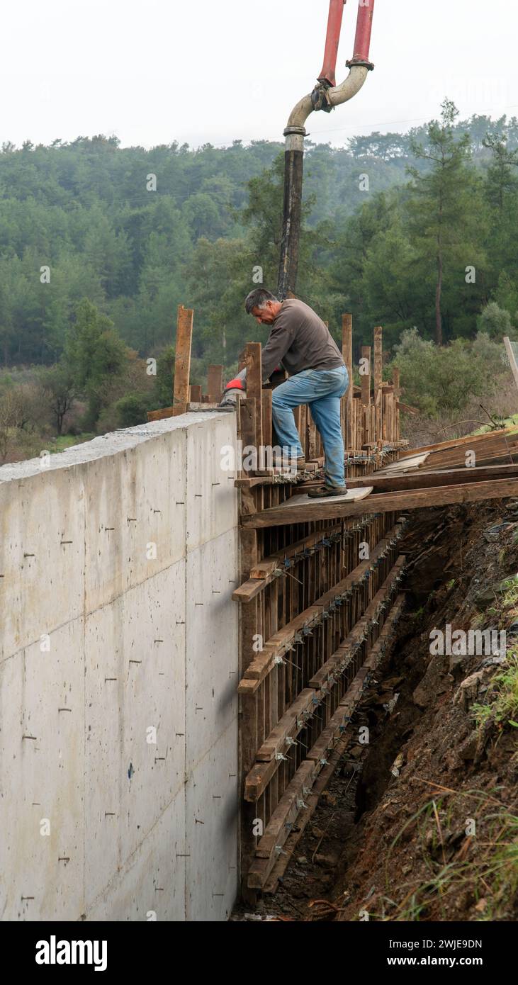 Istanbul, Turkey - 2 January 2024: Worker pouring wet cement mix from a ...