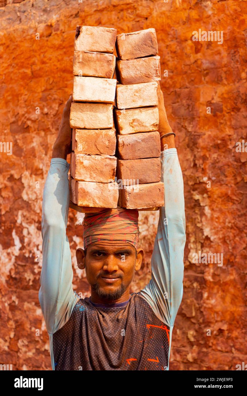 Dhaka, Dhaka, Bangladesh. 15th Feb, 2024. Workers carry piles of bricks ...
