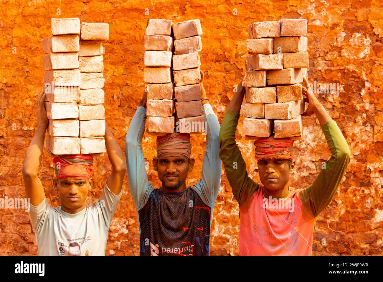 Dhaka, Dhaka, Bangladesh. 15th Feb, 2024. Workers carry piles of bricks ...