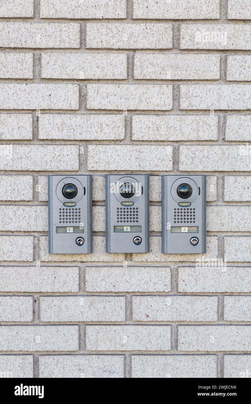 Three modern intercom on white wall near entrance to the house, space ...