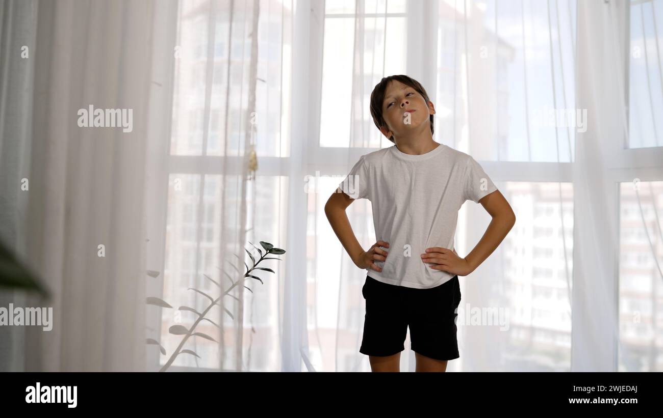 A boy does exercises in the morning at home. Little boy training at ...