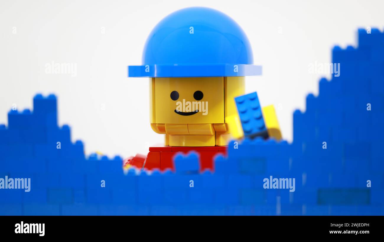 giant man build a brick wall piece by piece Stock Photo - Alamy