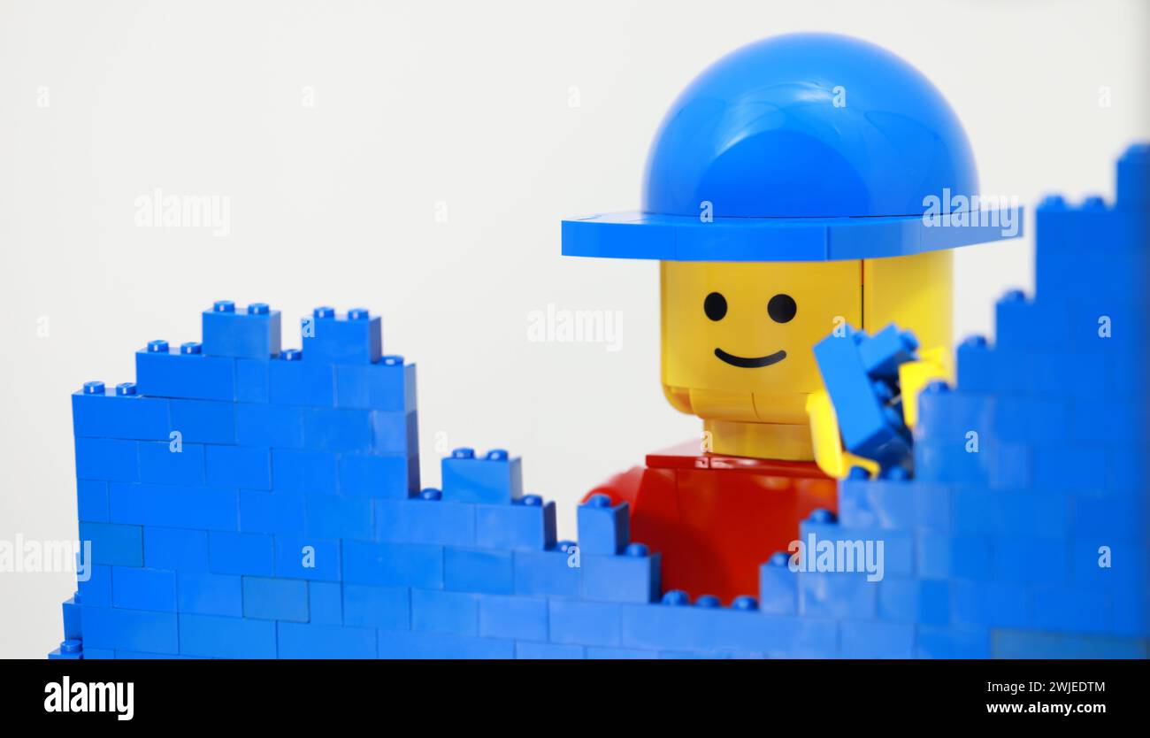 giant man build a brick wall piece by piece Stock Photo - Alamy