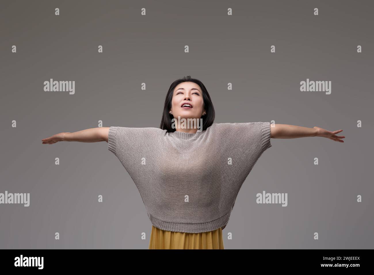 With closed eyes and outstretched arms, she seems to be embracing the ...