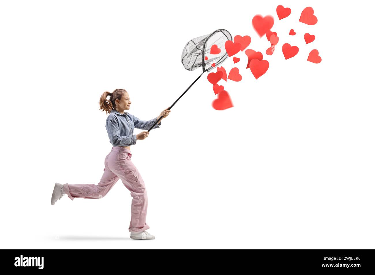 Teenage girl catching hearts with a net isolated on white background ...