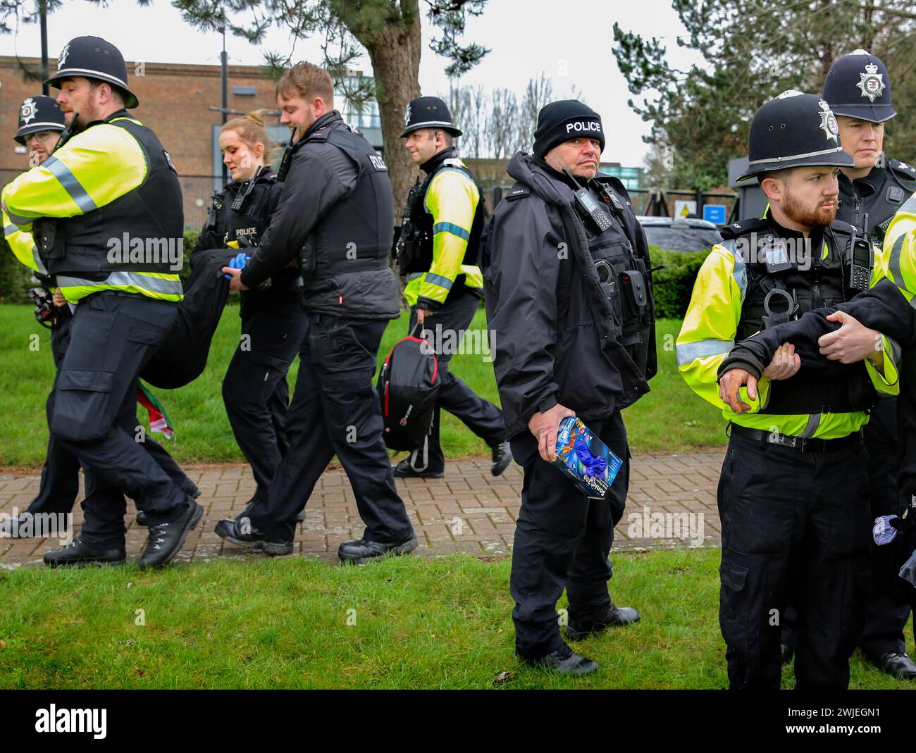 Police officers lead away two of three protesters, arrested after ...