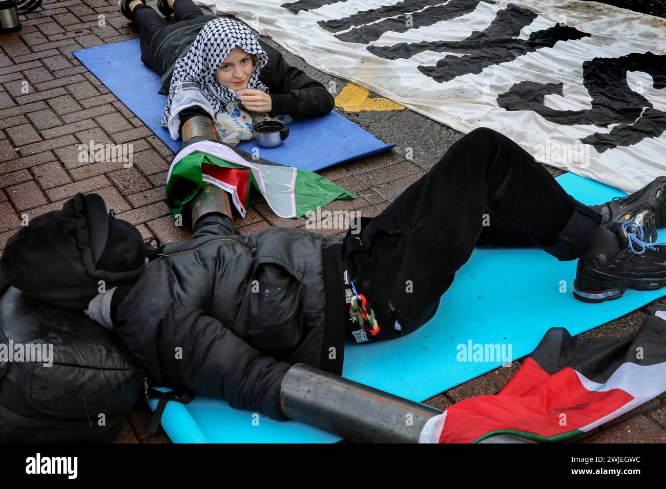 Protesters place themselves in a multi-person lock-on, blocking the ...