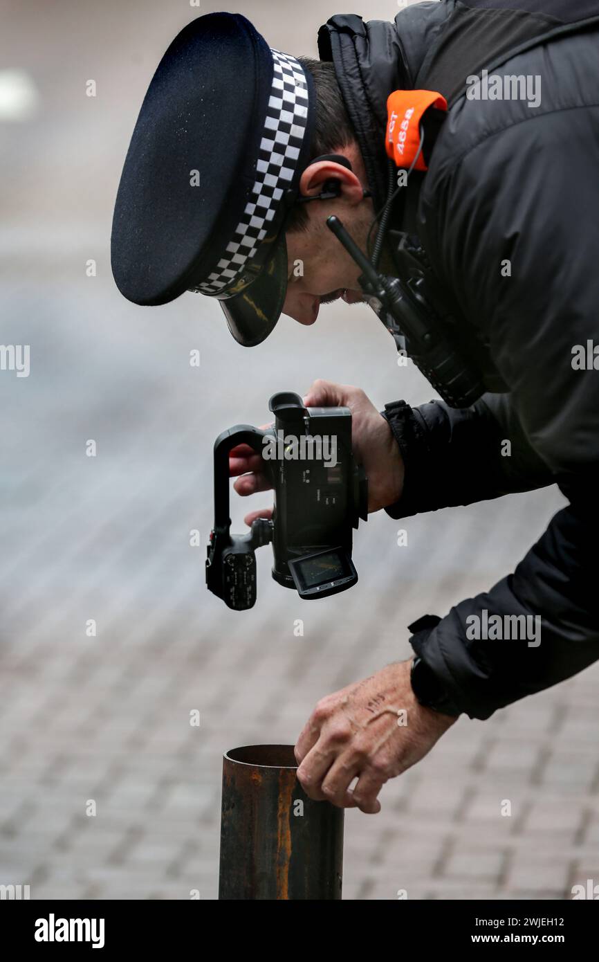 A police officer videos the inside of one of the lock-ons to gather ...