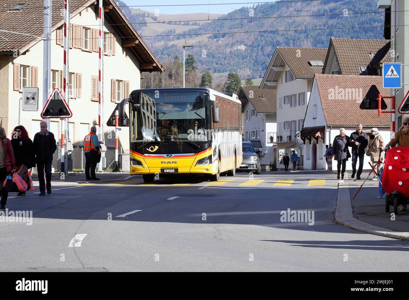 Anton Geisser 13.02.2024 Sarnen OW Schweiz. Bild : Postauto faehrt ueber Bahnuebergang *** Anton ...
