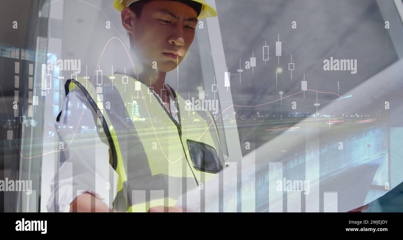 Asian architect reviews building plan with graphics Stock Photo - Alamy