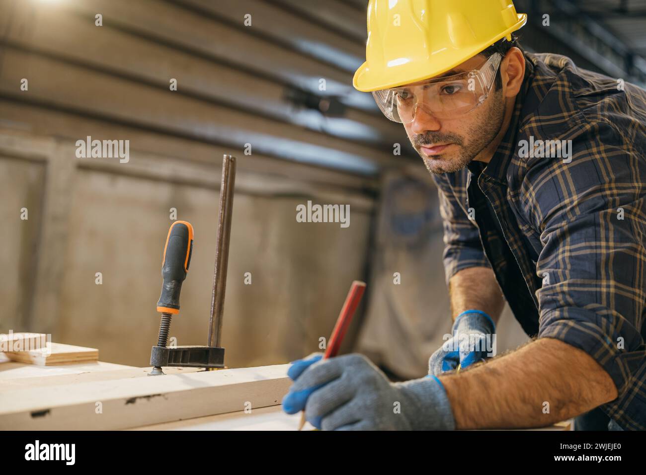 Carpenter man wear gloves during working using tape measure and pencil ...