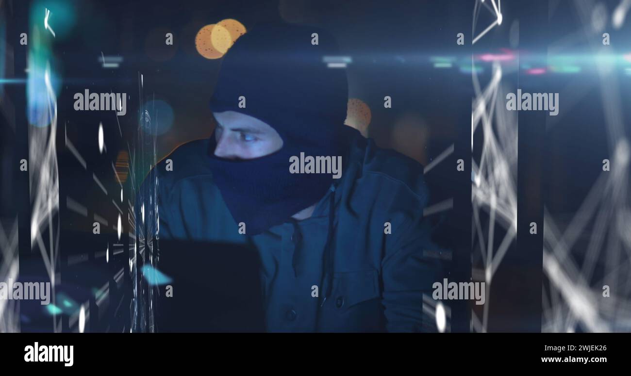 Image of digital interface with data processing over male hacker in balaclava using laptop Stock ...