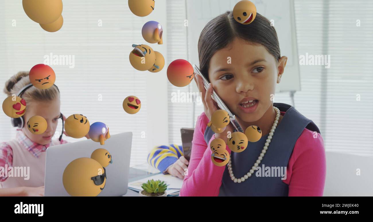 Image of digital interface with emoji icons floating over children ...
