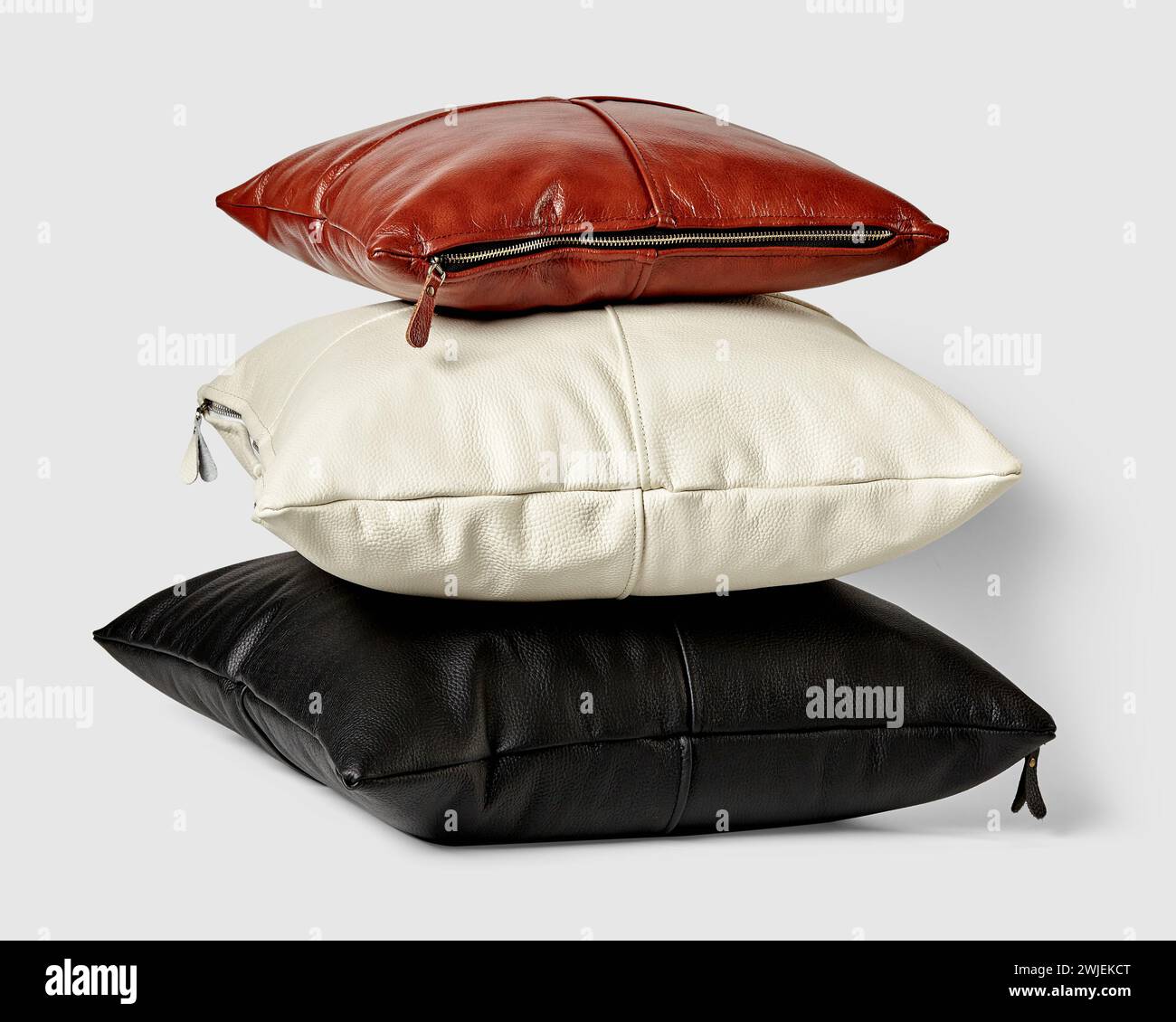 Stack of leather pillows of different sizes in black, white, and brown ...