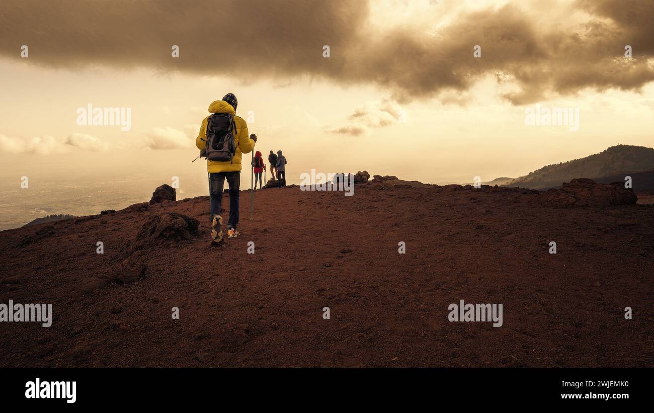 Hikers trekking across the volcanic terrain of Mount Etna - Adventure ...