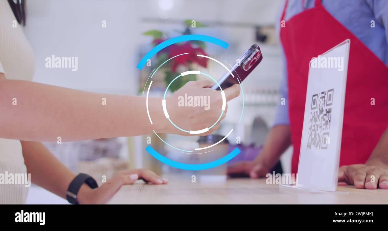 Image of scope scanning over diverse shop assistant and customer paying ...