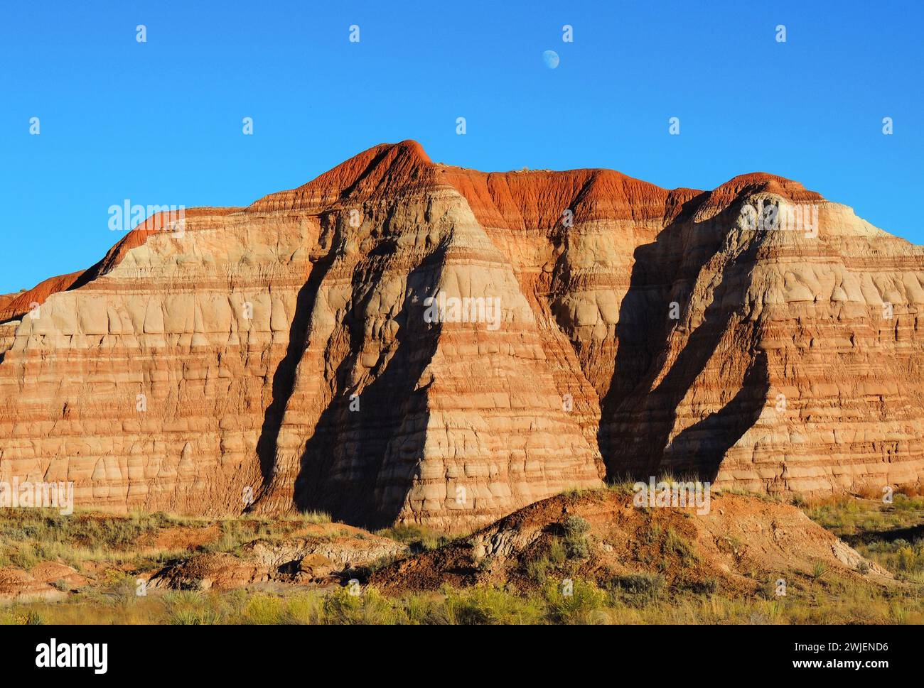 picturesque red and white eroded cliffs and the moon along the paria ...