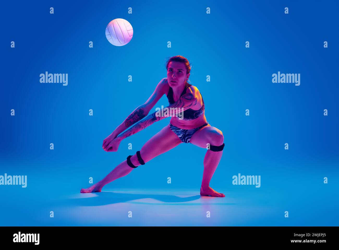 Young woman, volleyball player in motion, training, playing against ...