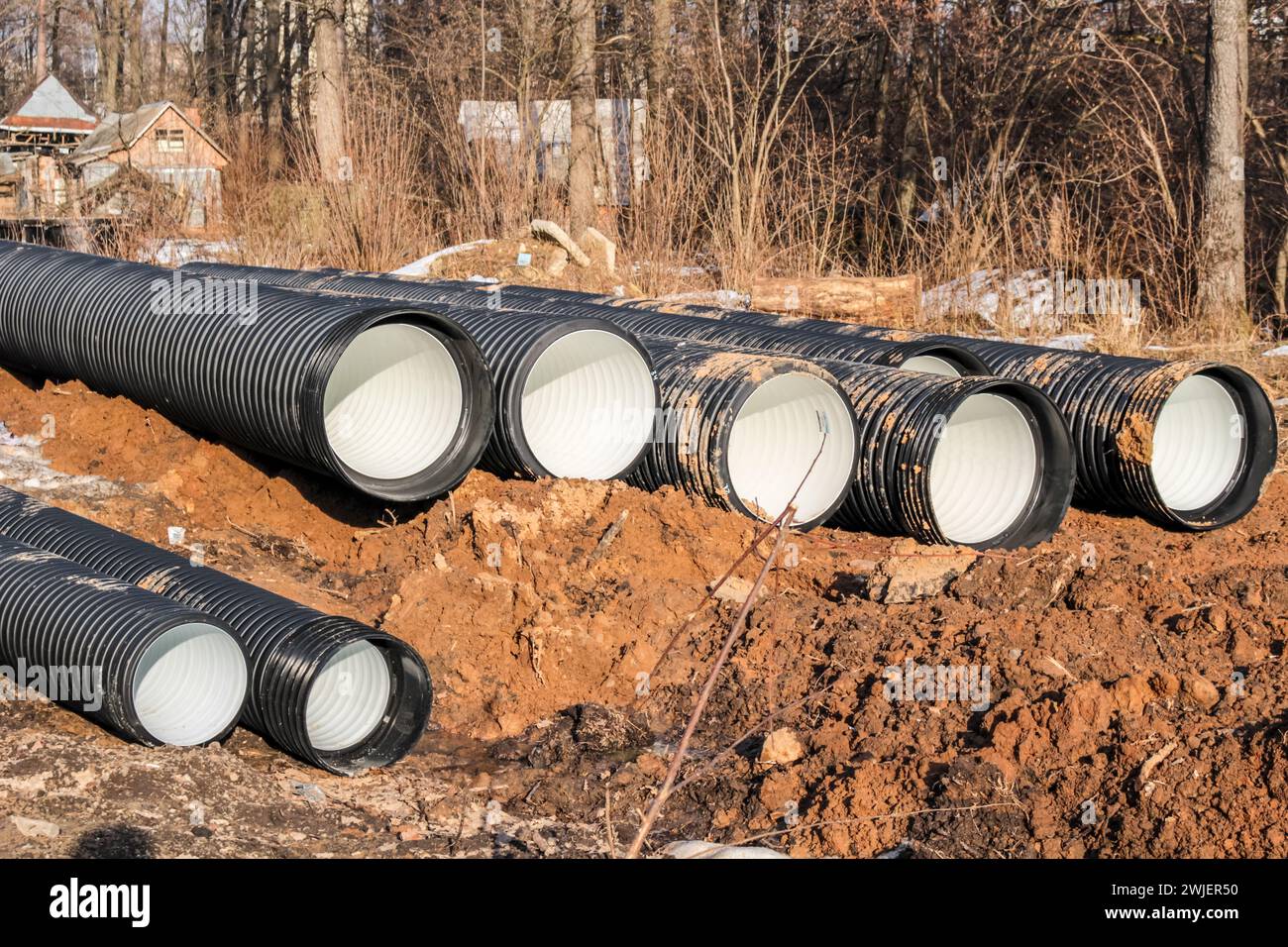 Pipeline laying in the ground. Black plastic pipes Stock Photo - Alamy