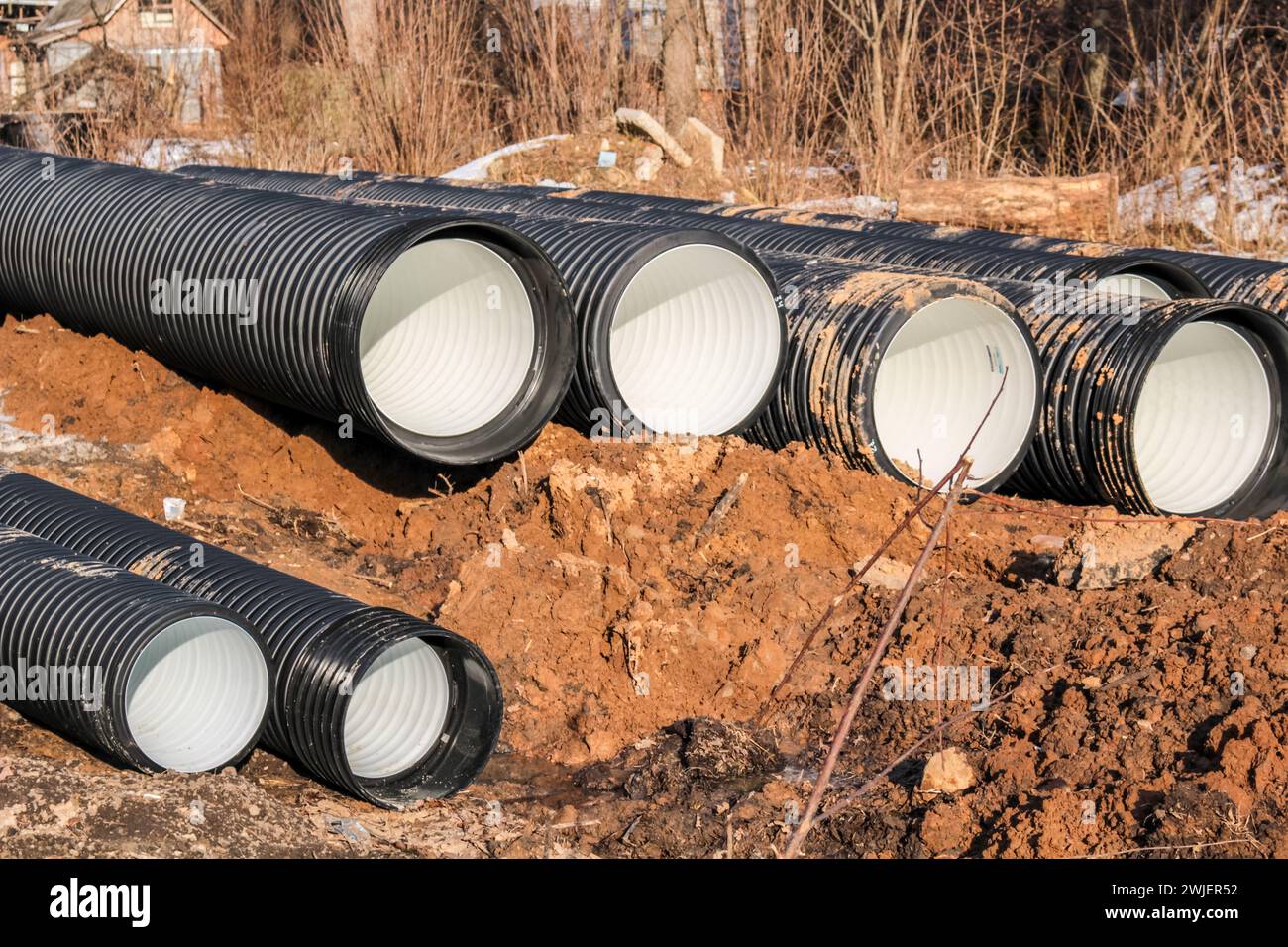 Pipeline laying in the ground. Black plastic pipes Stock Photo - Alamy