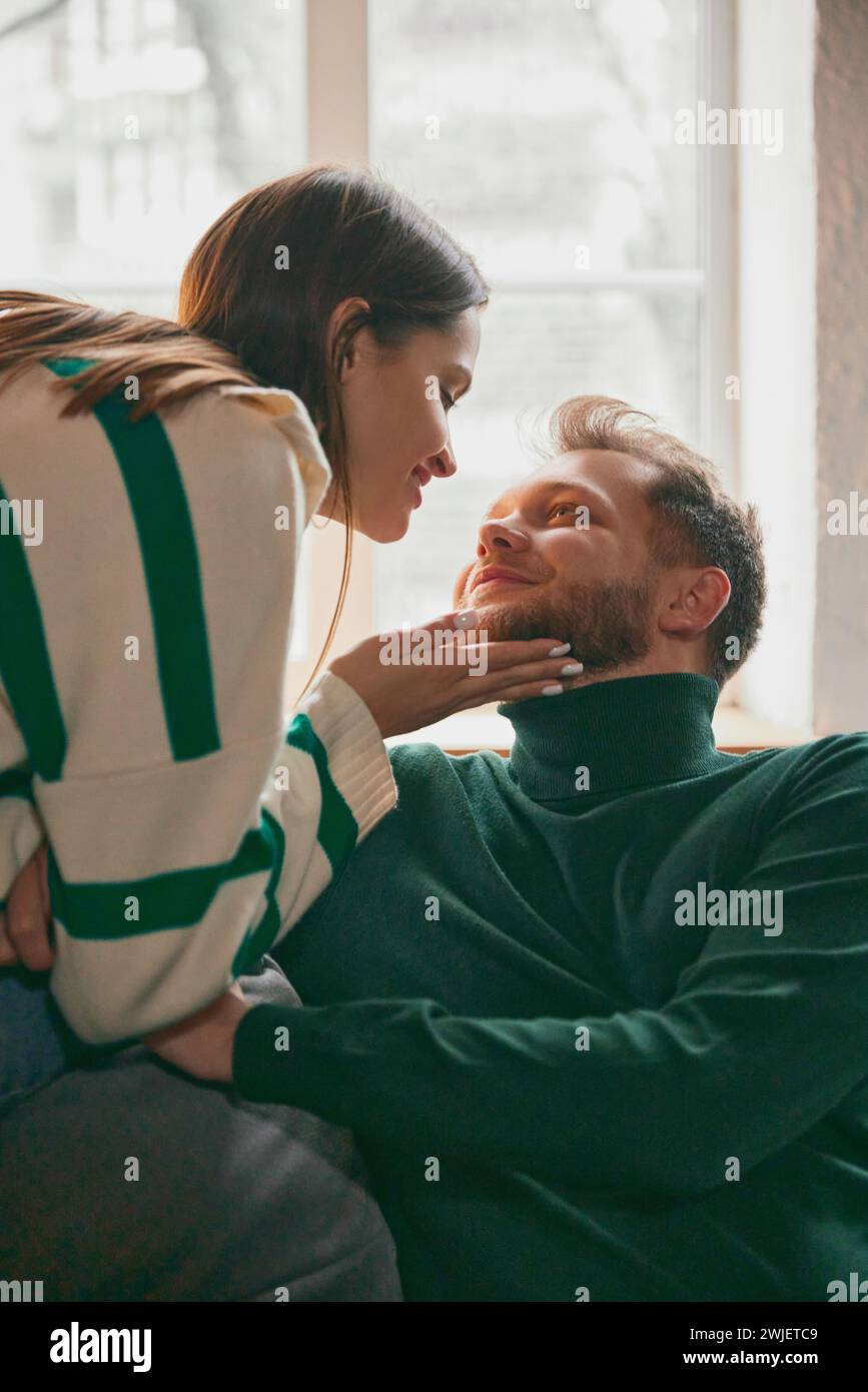Cute moment between smiling couple, woman touching man's face lovingly ...