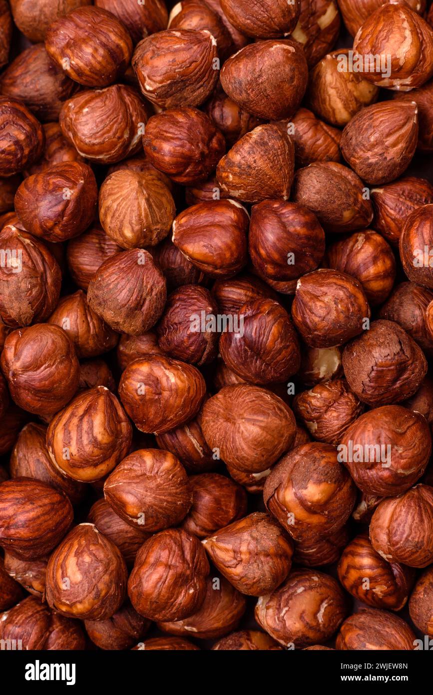 Delicious hazelnut whole, raw, without shell, on a dark concrete ...