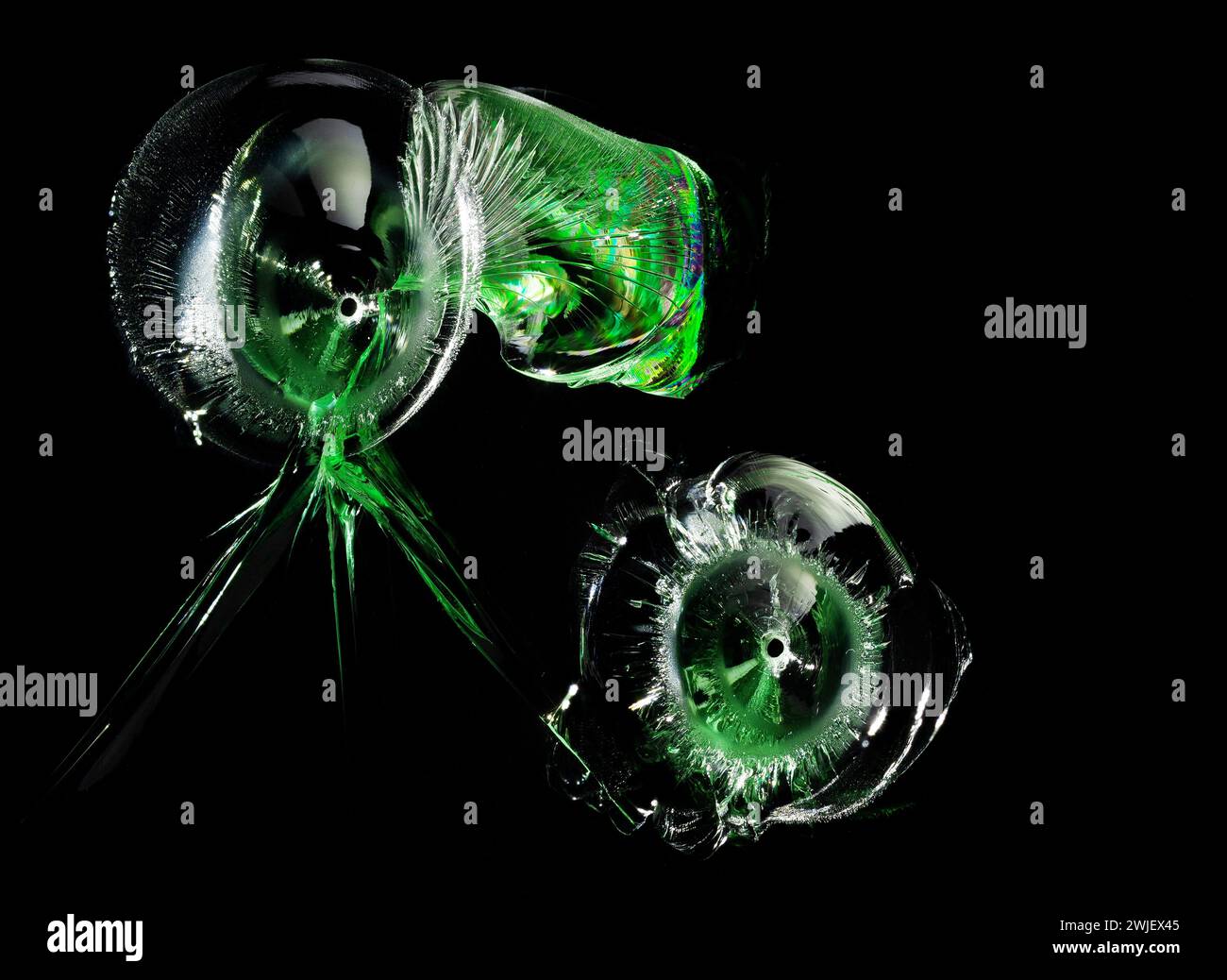 Cracked glass. Bullet holes with green reflections in glass on black ...