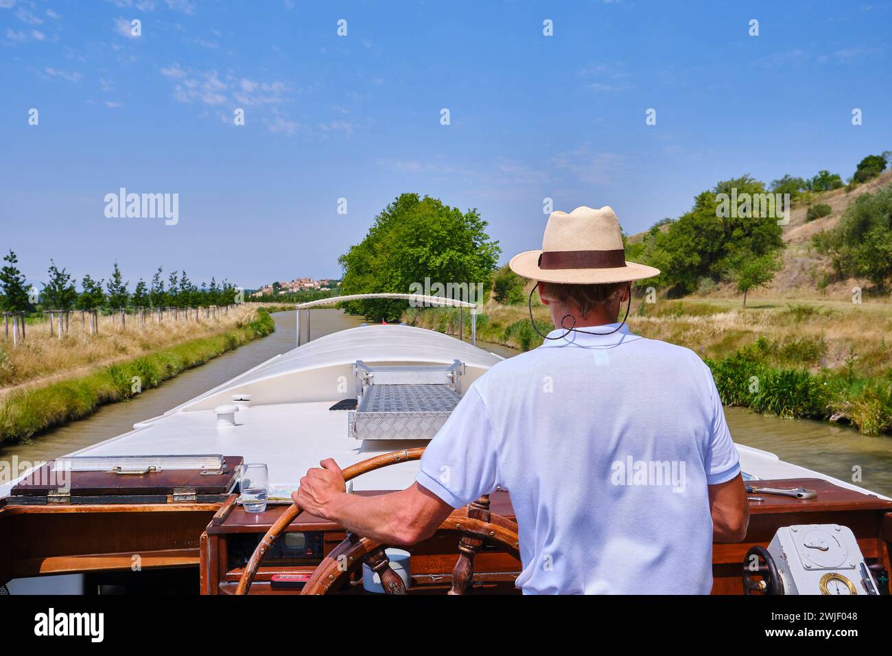 Pilot and cockpit of the barge “Enchantee” on the Canal du Midi. The ...