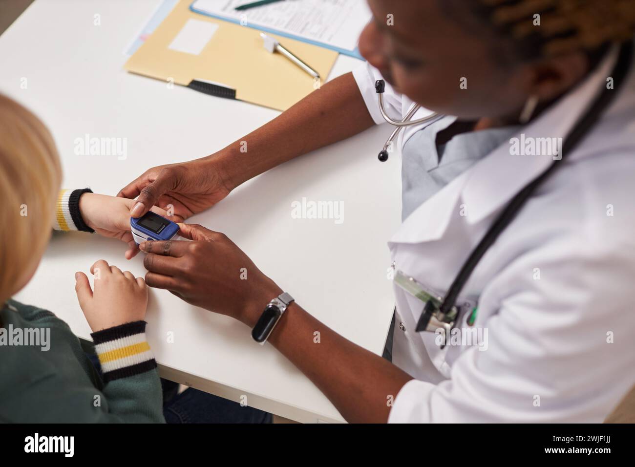 Top view closeup of female doctor measuring oxygen saturation of child ...