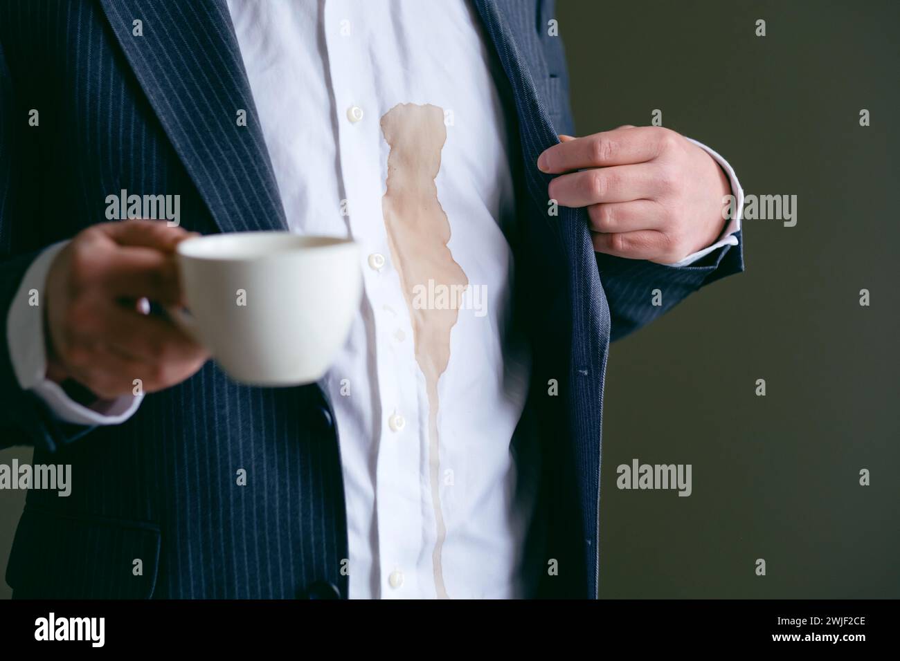 An unrecognizable man spilled coffee or tea on a white shirt. daily ...