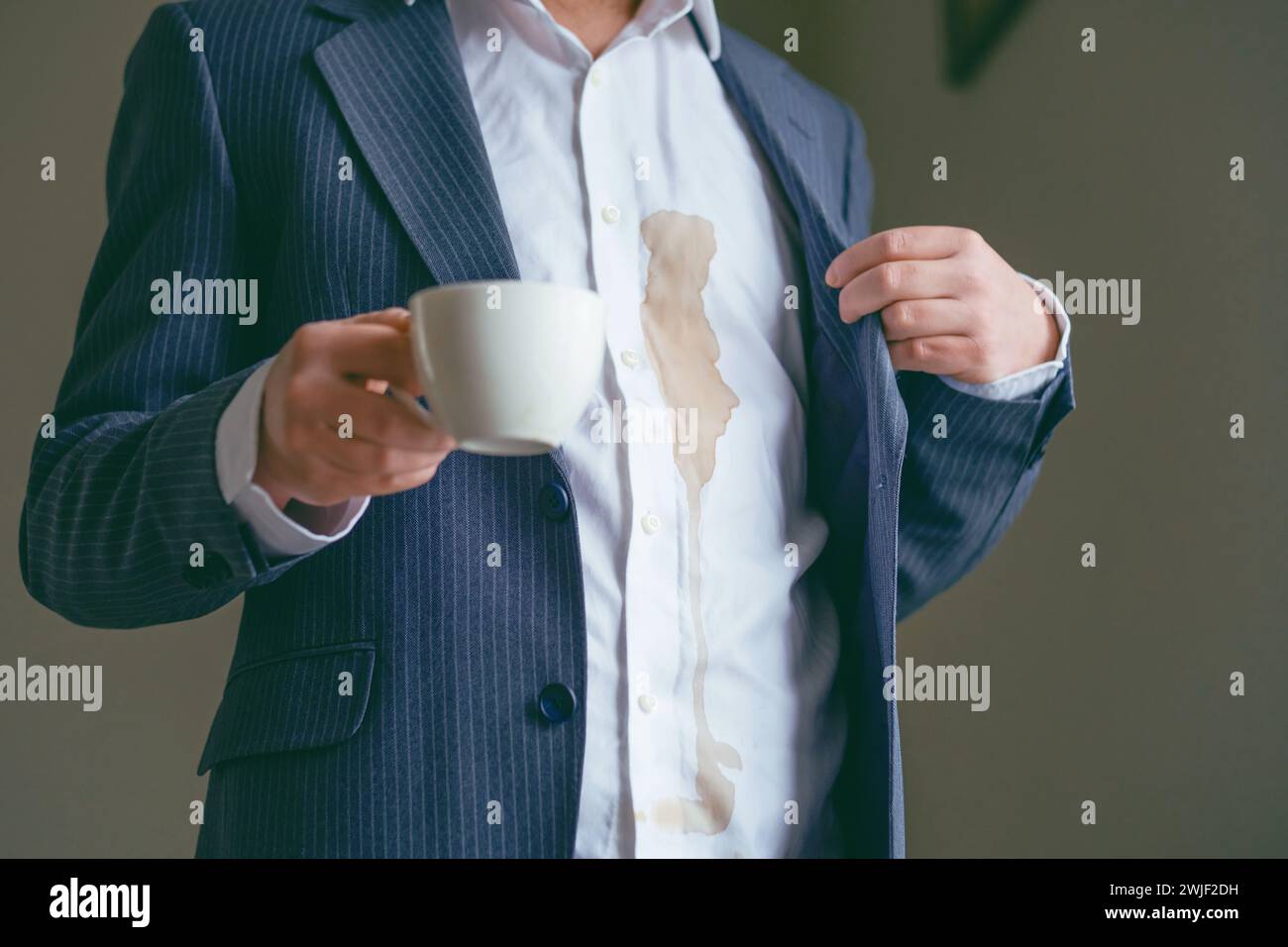 An unrecognizable man spilled coffee or tea on a white shirt. daily ...
