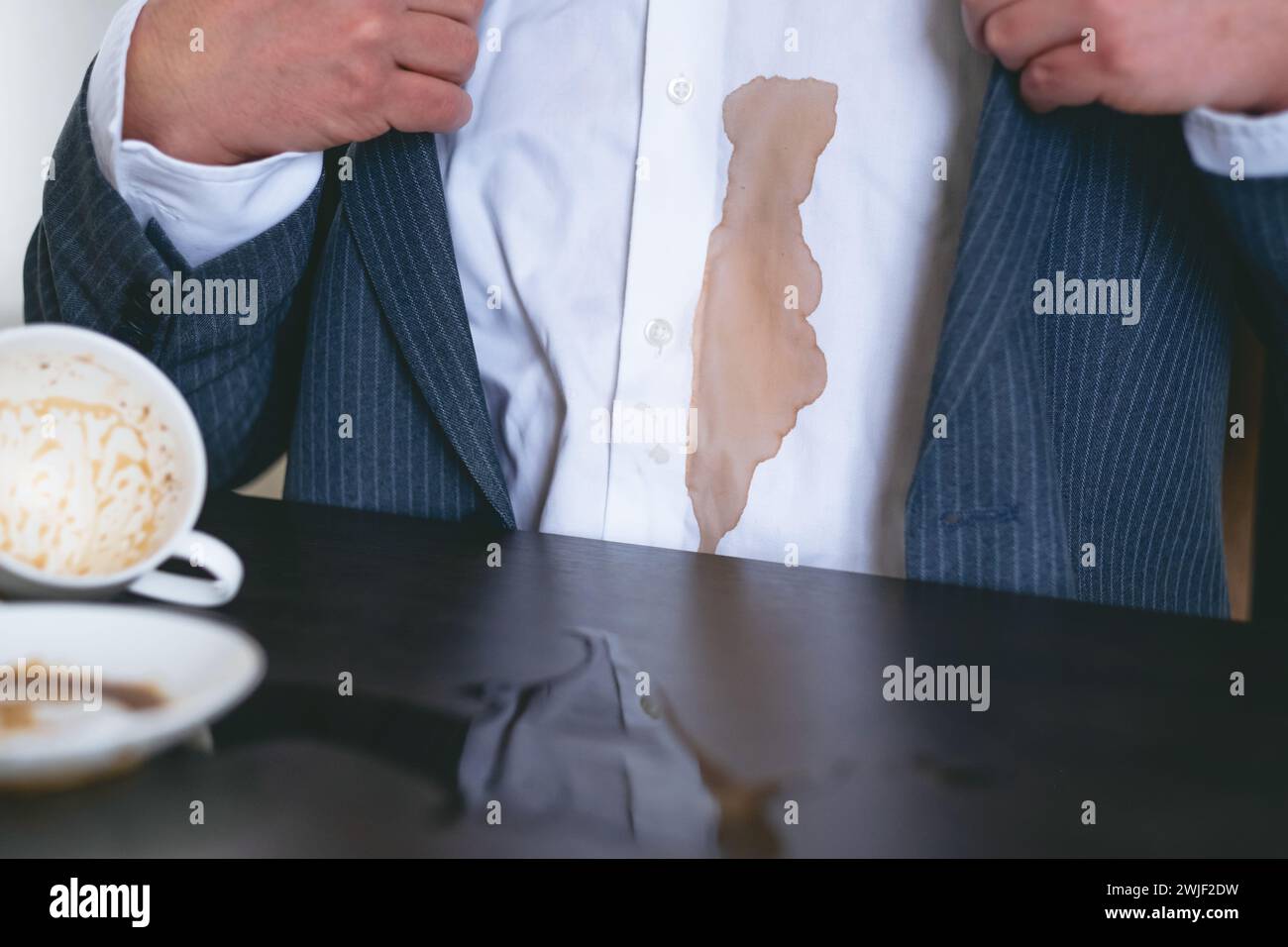 An unrecognizable man spilled coffee or tea on a white shirt. daily ...