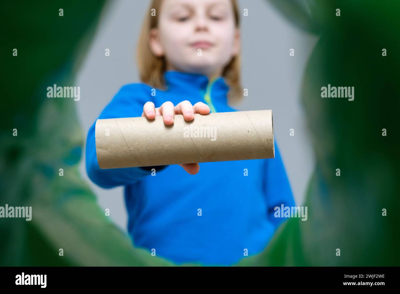 Low angle view child roll up Kraft paper or roll of toilet paper in a ...
