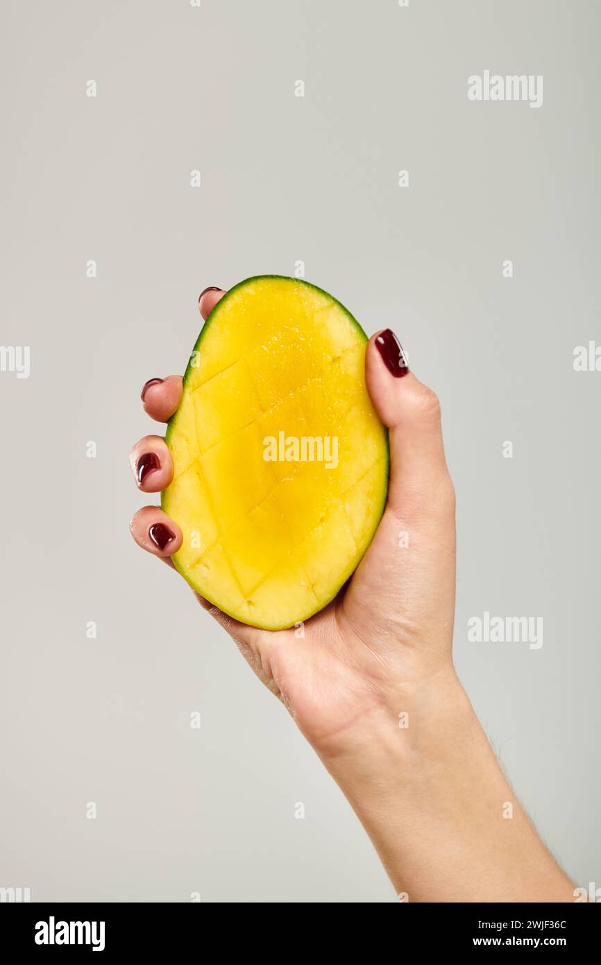 object photo of gourmet juicy mango in hand of young unknown female ...