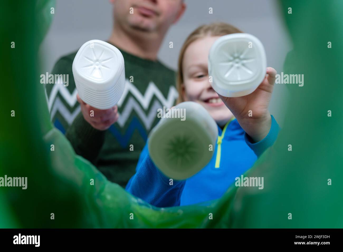 Low angle view a family sorting plastic bottles recycle bin in home ...