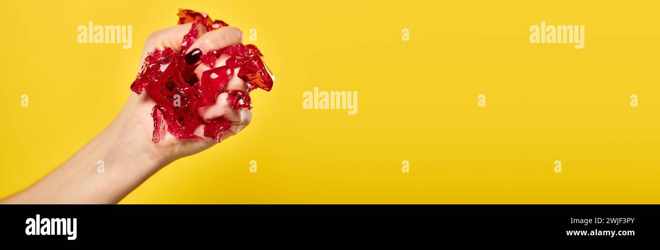 unknown woman with nail polish squeezing red jello in her hand on ...