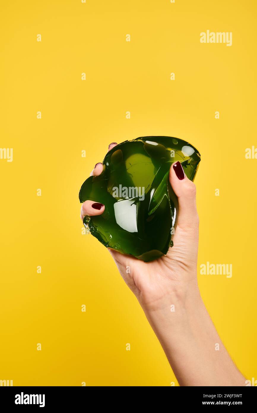object photo of delicious green jello in hand of unknown female model ...