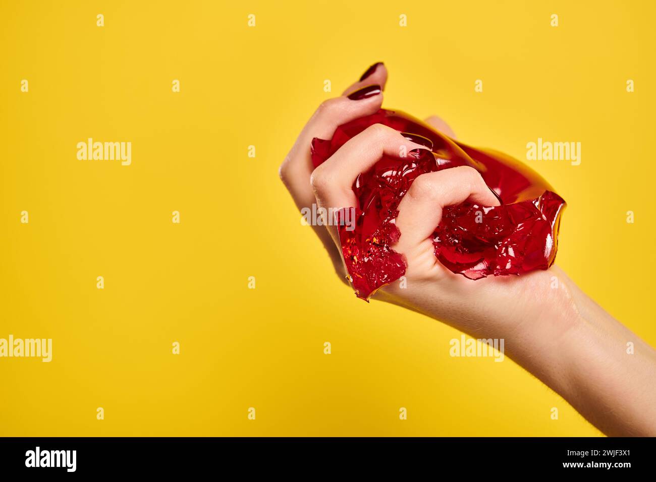 unknown female model squeezing red delicious jello in her hand on ...