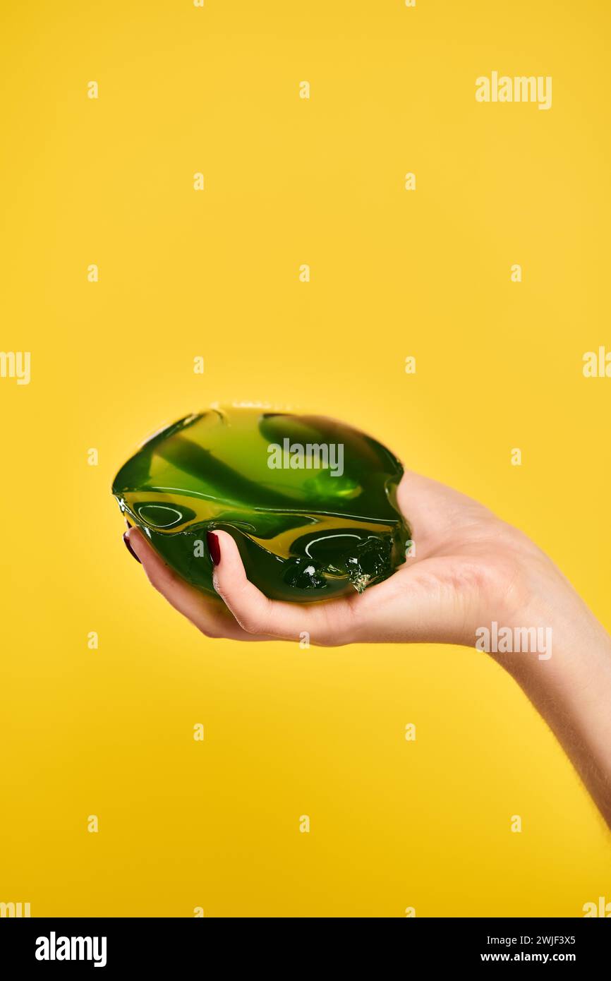 object photo of sweet green jello in hand of young unknown female model ...