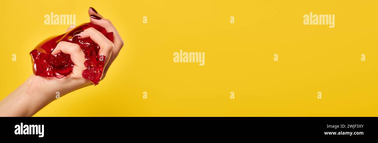 unknown female model squeezing red tasty jello in her hand on vibrant ...