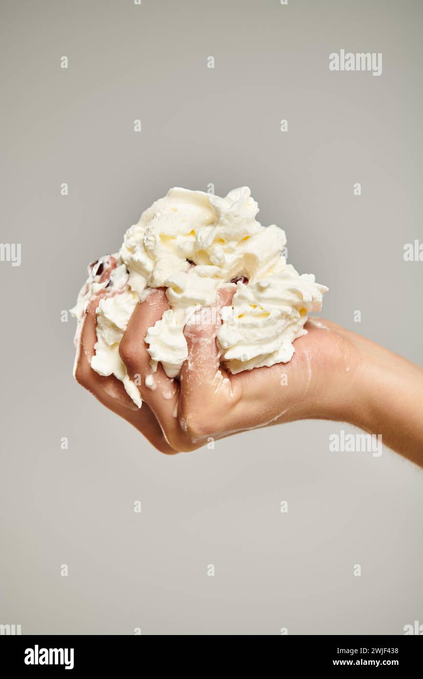 object photo of sweet gourmet whipped cream in hand of unknown female ...