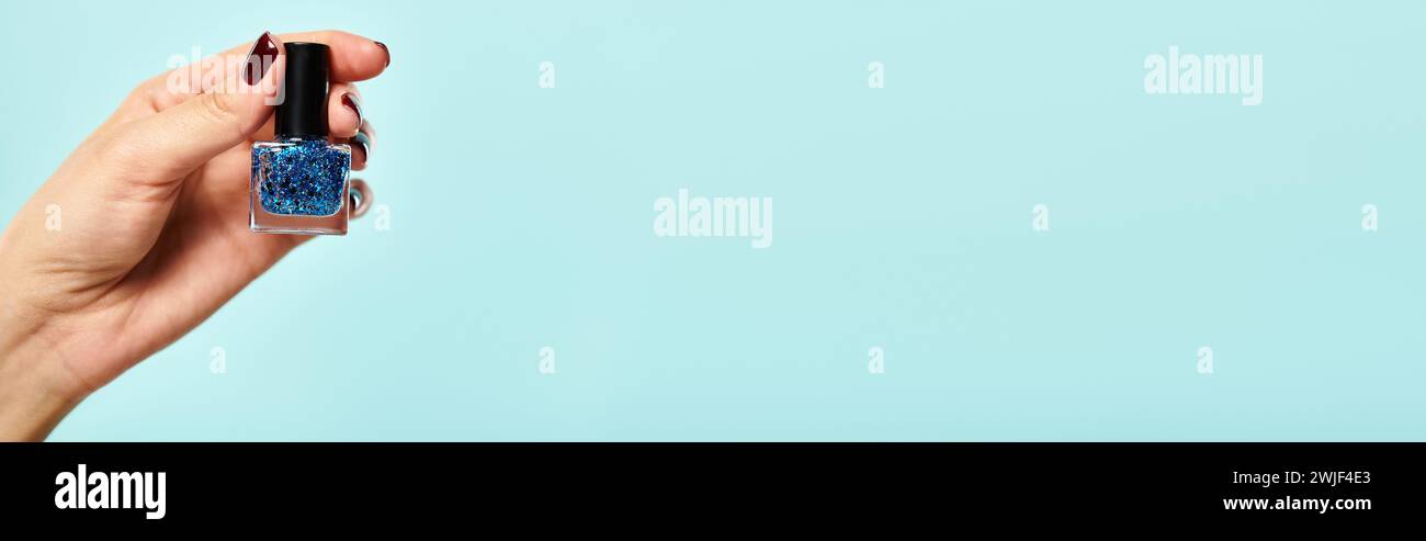 object photo of blue nail polish in hand of young unknown female model ...