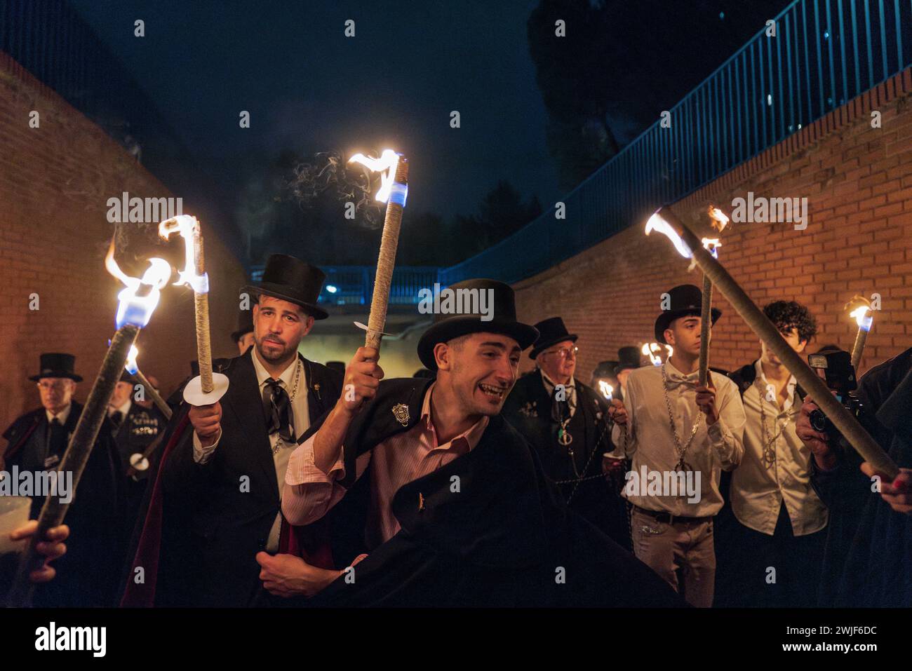 Members of the brotherhood of the sardine are seen carrying torches ...