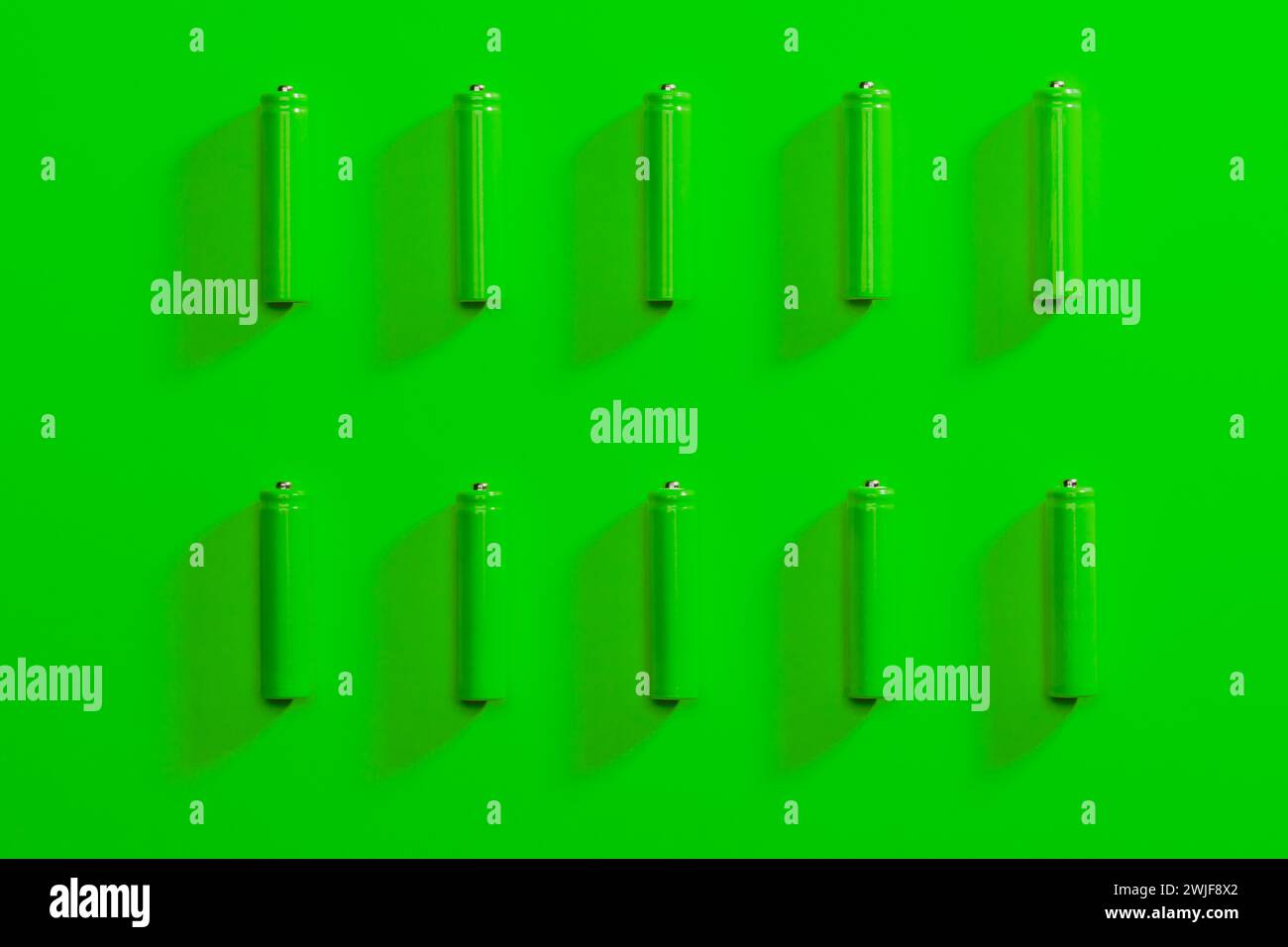 AAA alkaline batteries arranged in rows on a vibrant green background ...
