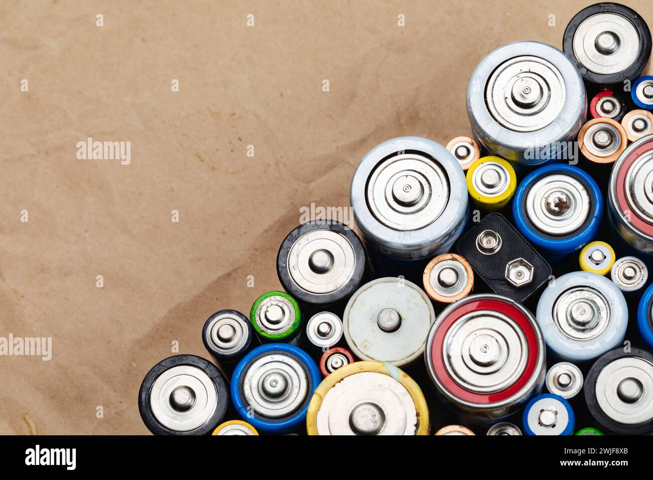 Top view of various used disposable alkaline batteries showcasing a mix ...