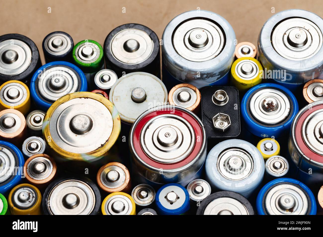 Top view of various used disposable alkaline batteries showcasing a mix ...