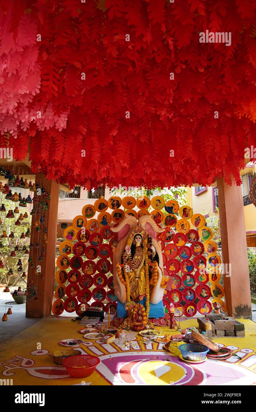 Clay idol of Goddess Saraswati in a garage turned makeshift decorative ...