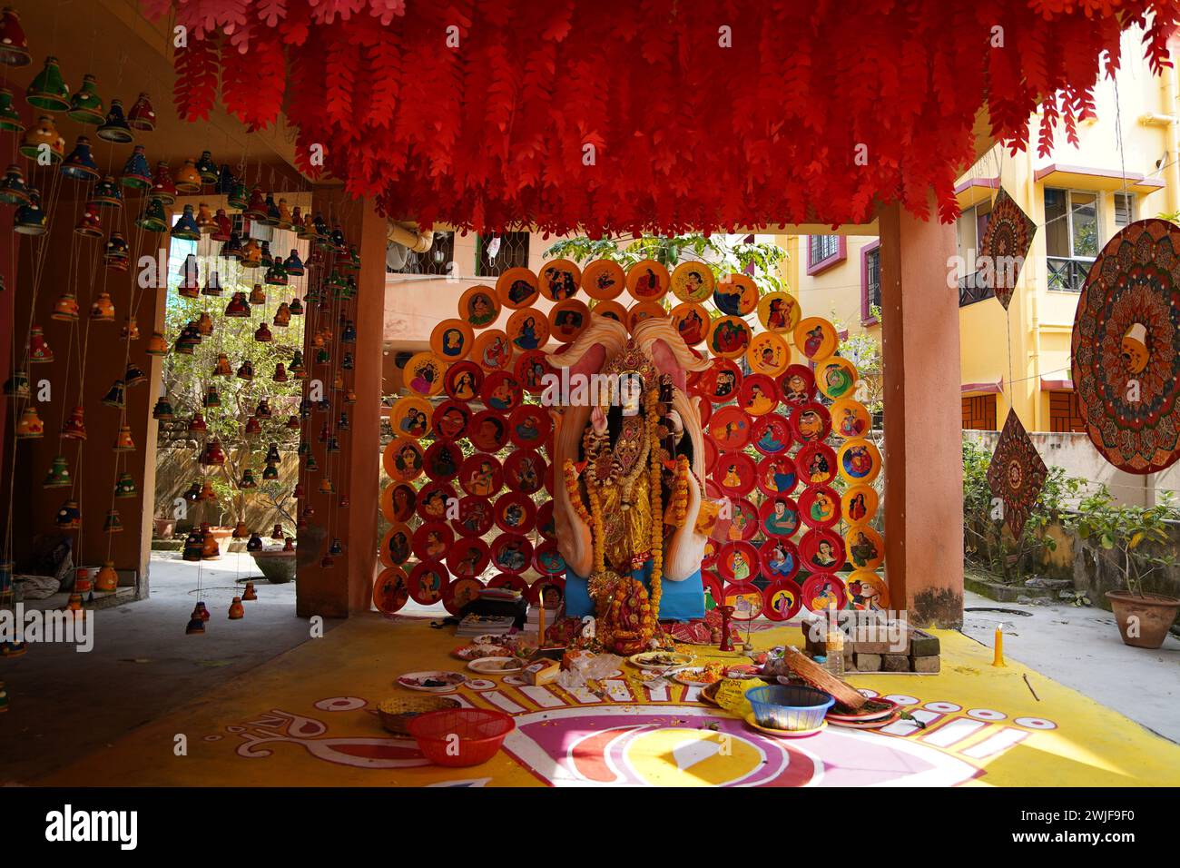 Clay idol of Goddess Saraswati in a garage turned makeshift decorative ...