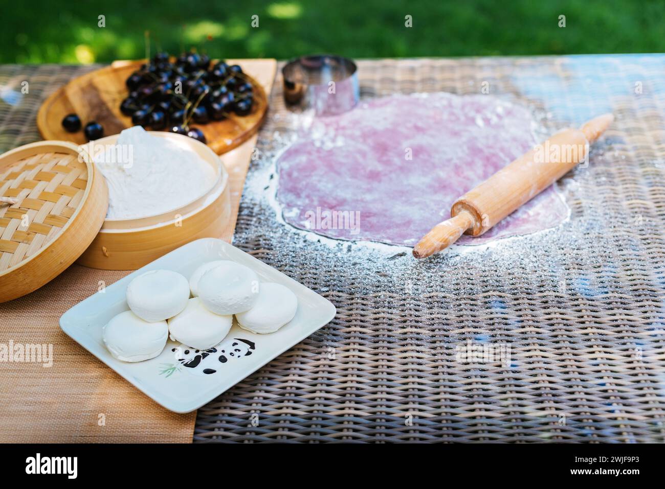 a rolling pin is on a table next to a bowl of blueberries and a bowl of ...